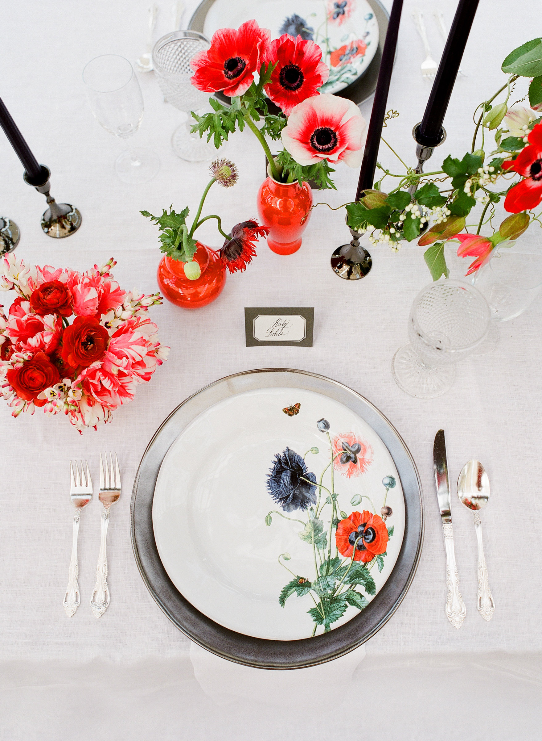 Brigh floral plates and red floral centerpieces - photo by Corbin Gurkin