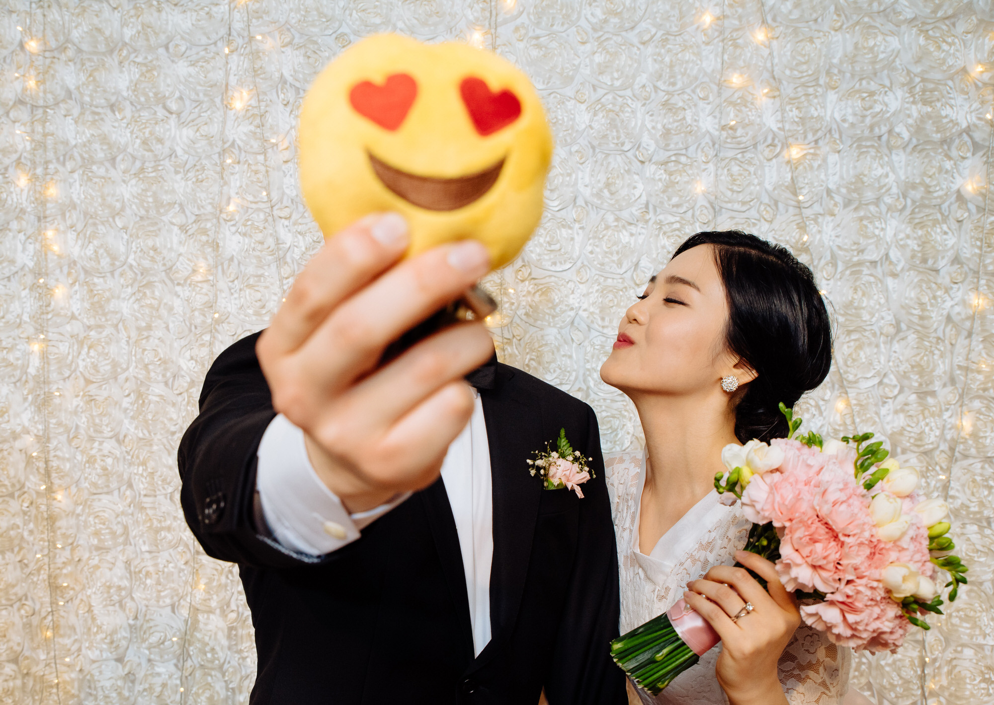 Groom holds up smiley face emoji - photo by Ken Pak