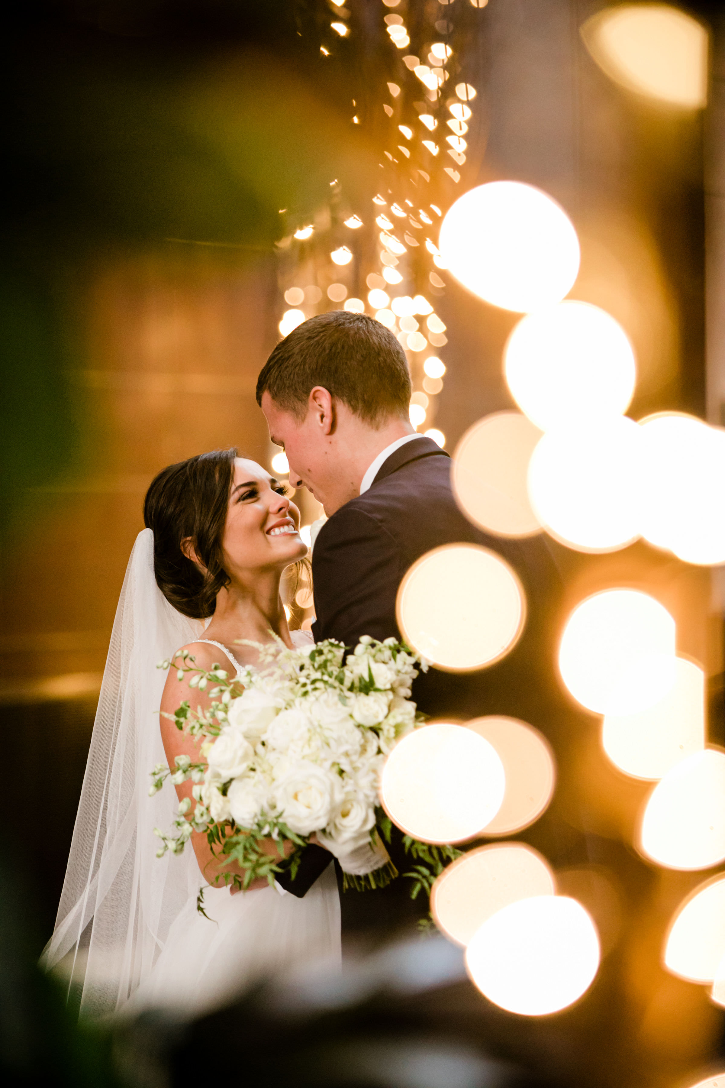 Bokeh portrait of bride smiling up at groom - photo by Alante Photography