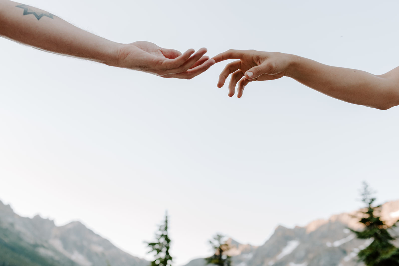 Fingertips touching against mountain backdrop Olympic Sculpture Park ...