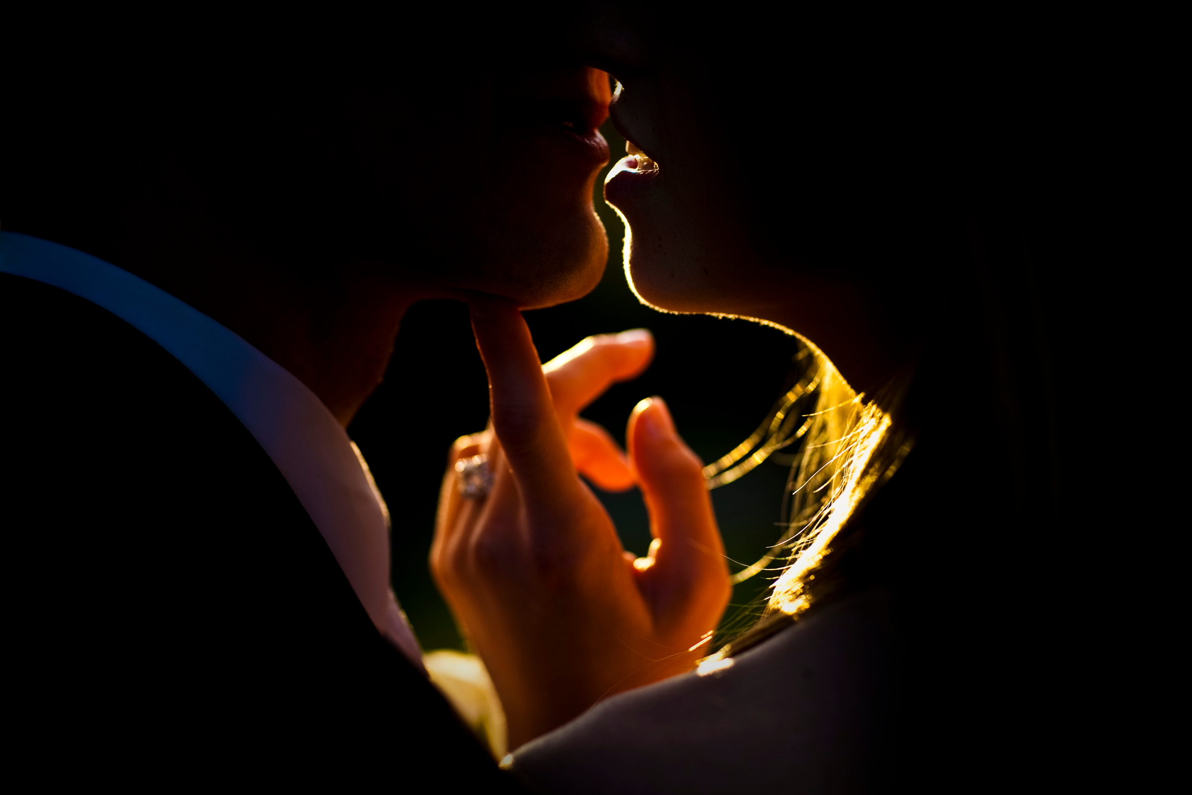 Closeup about to kiss outlined in light - photo by Chrisman Studios