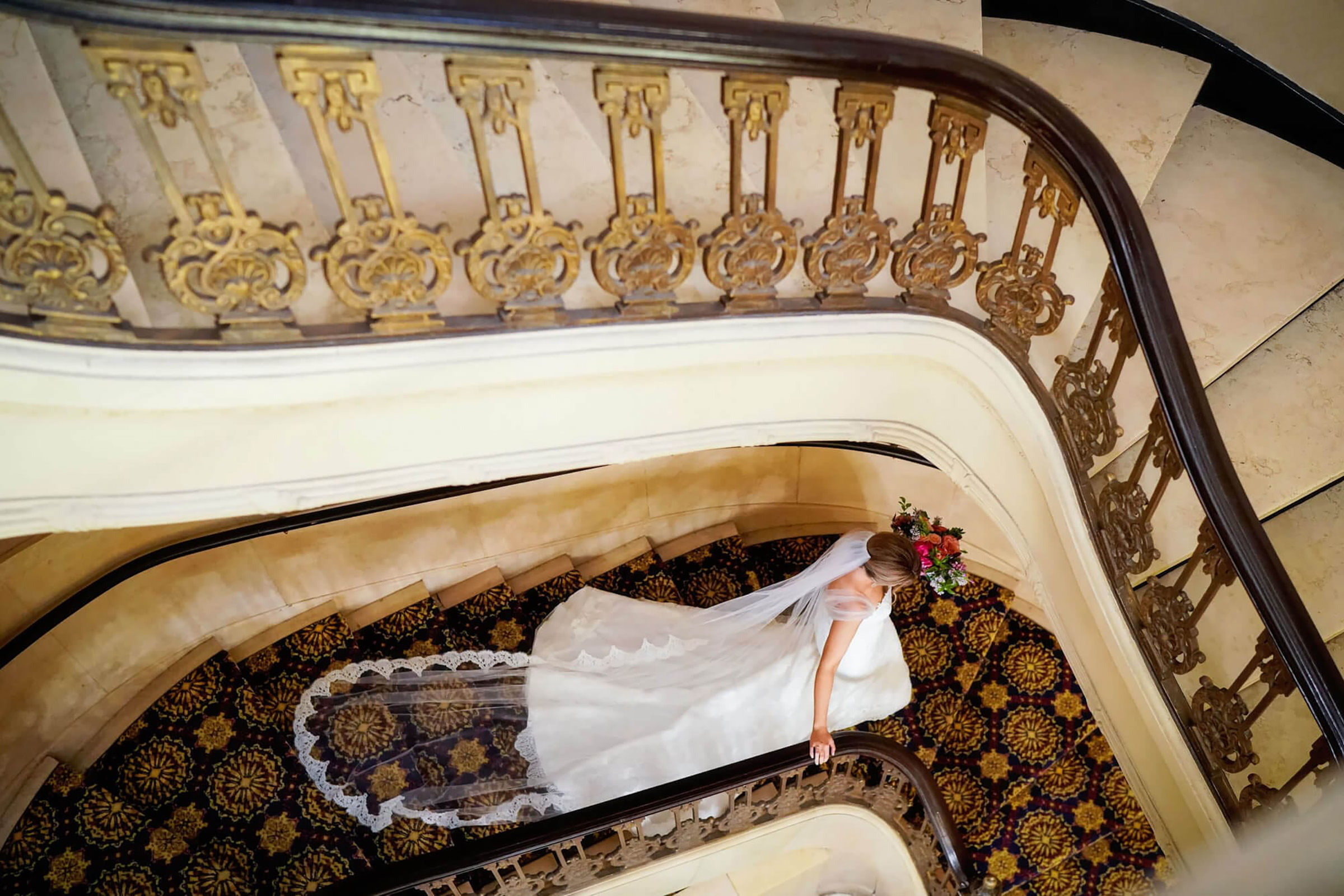 Aerial view of bride descending ornate staircase - photo by Kate ...