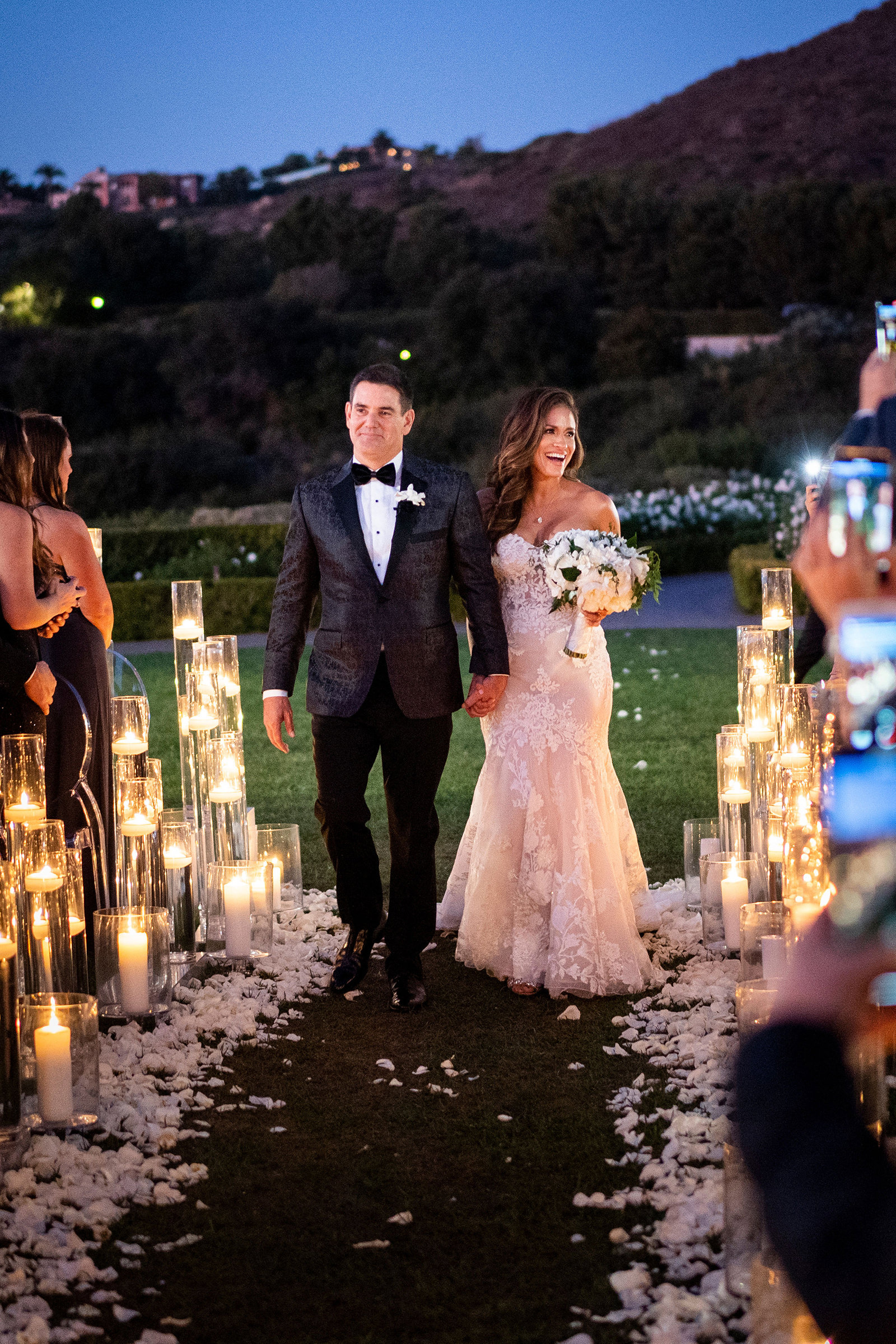 Evening luxury couple recessional with candlelight and flower petals ...