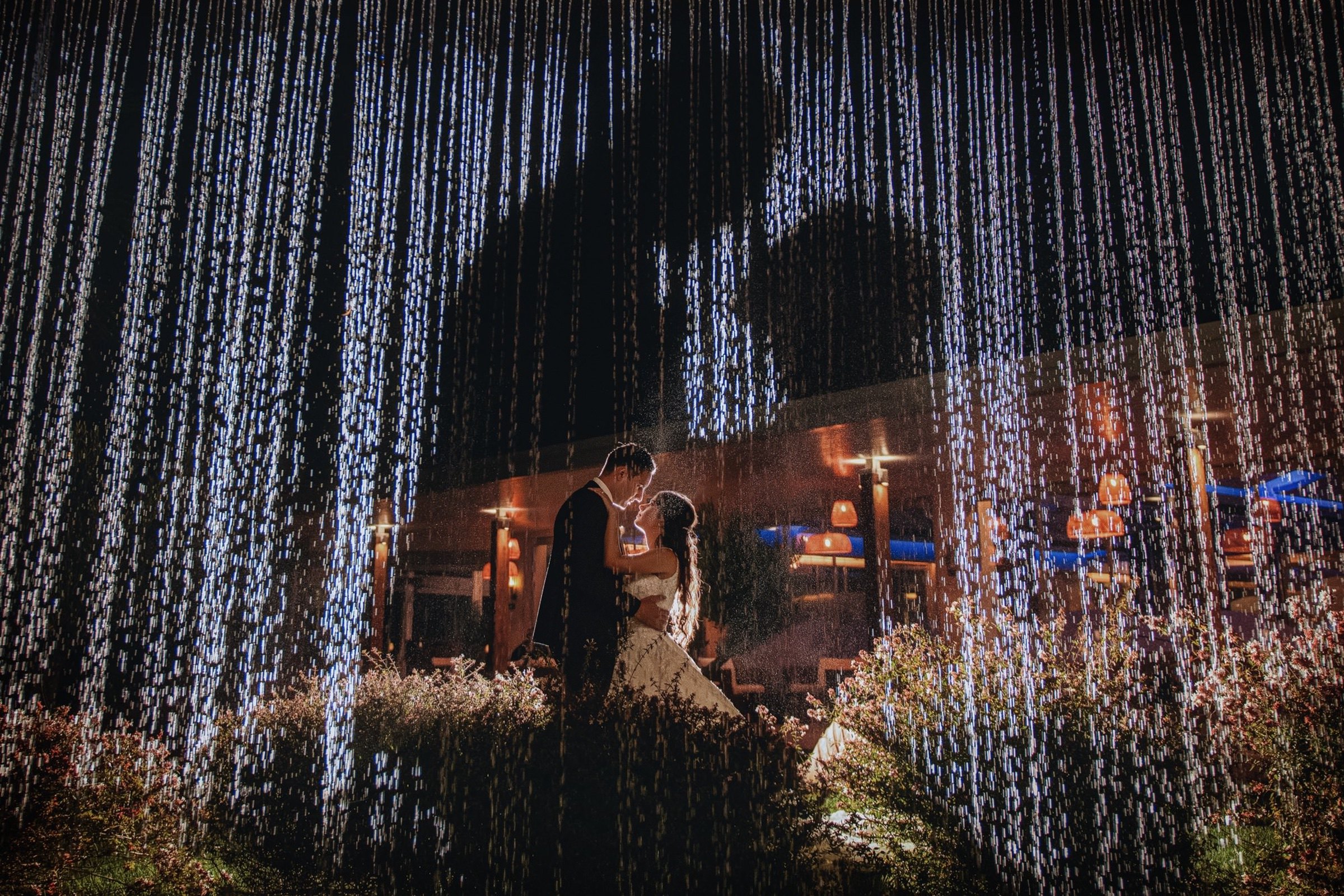 Face to face couple with projected shadow on wall of falling water ...