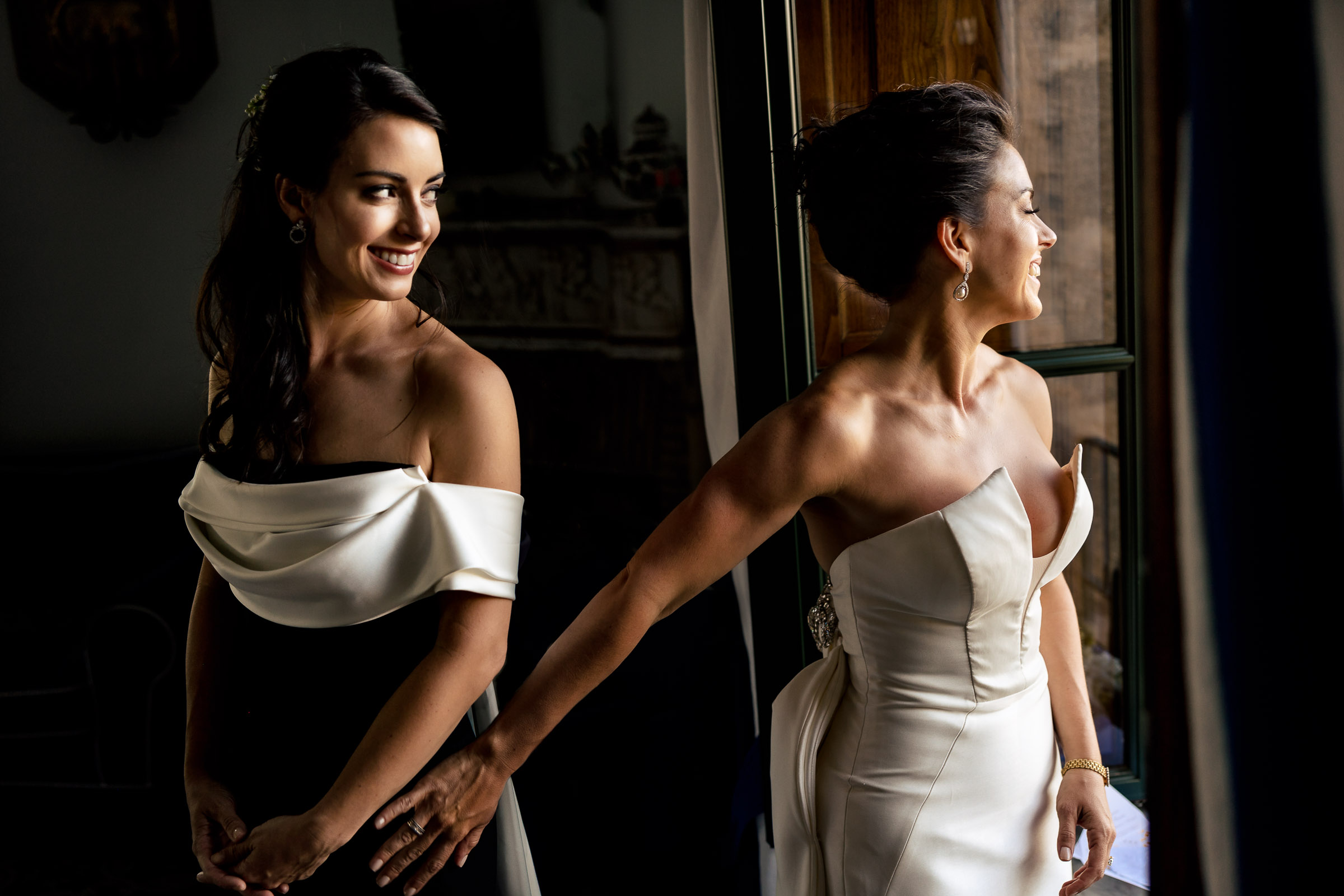 Bride by window reaching behind - photo by JOS & TREE