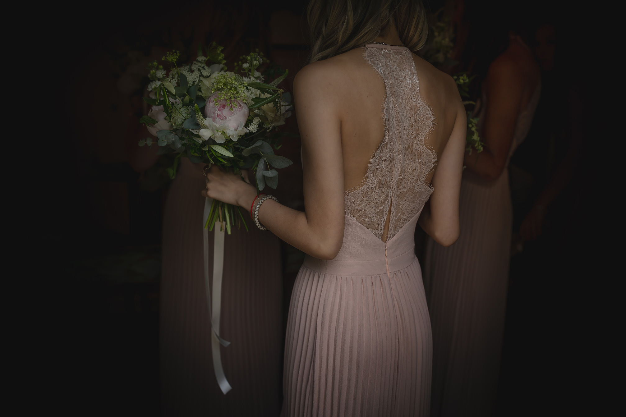 Back of bridesmaid showing bouquet and backless gown - photo by Andrea ...