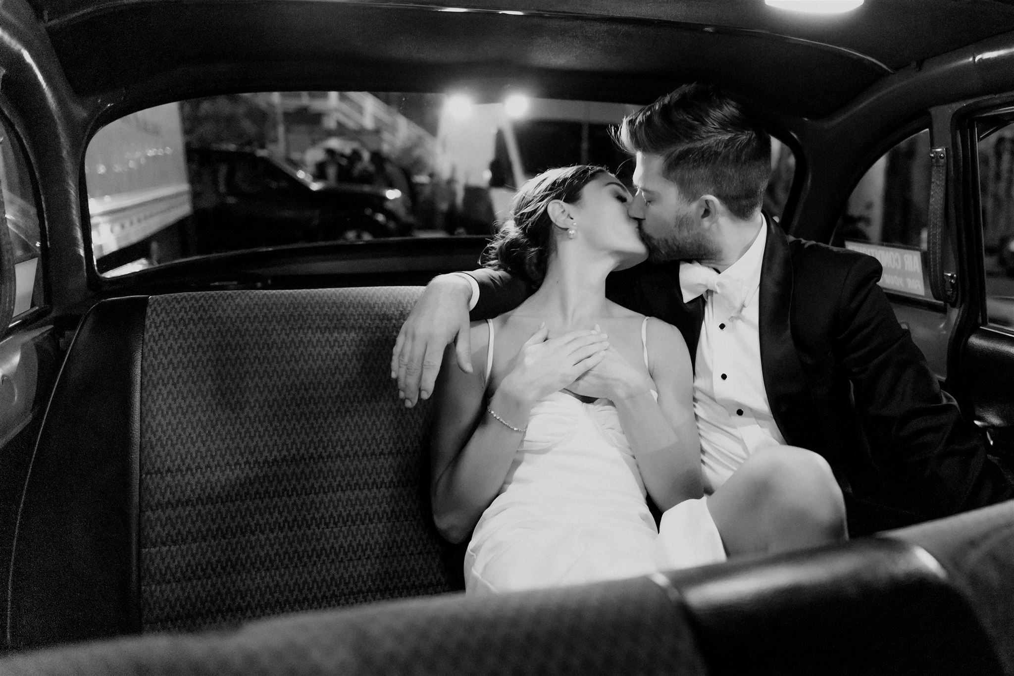 Bride and groom kissing in limo - photo by j.olson weddings