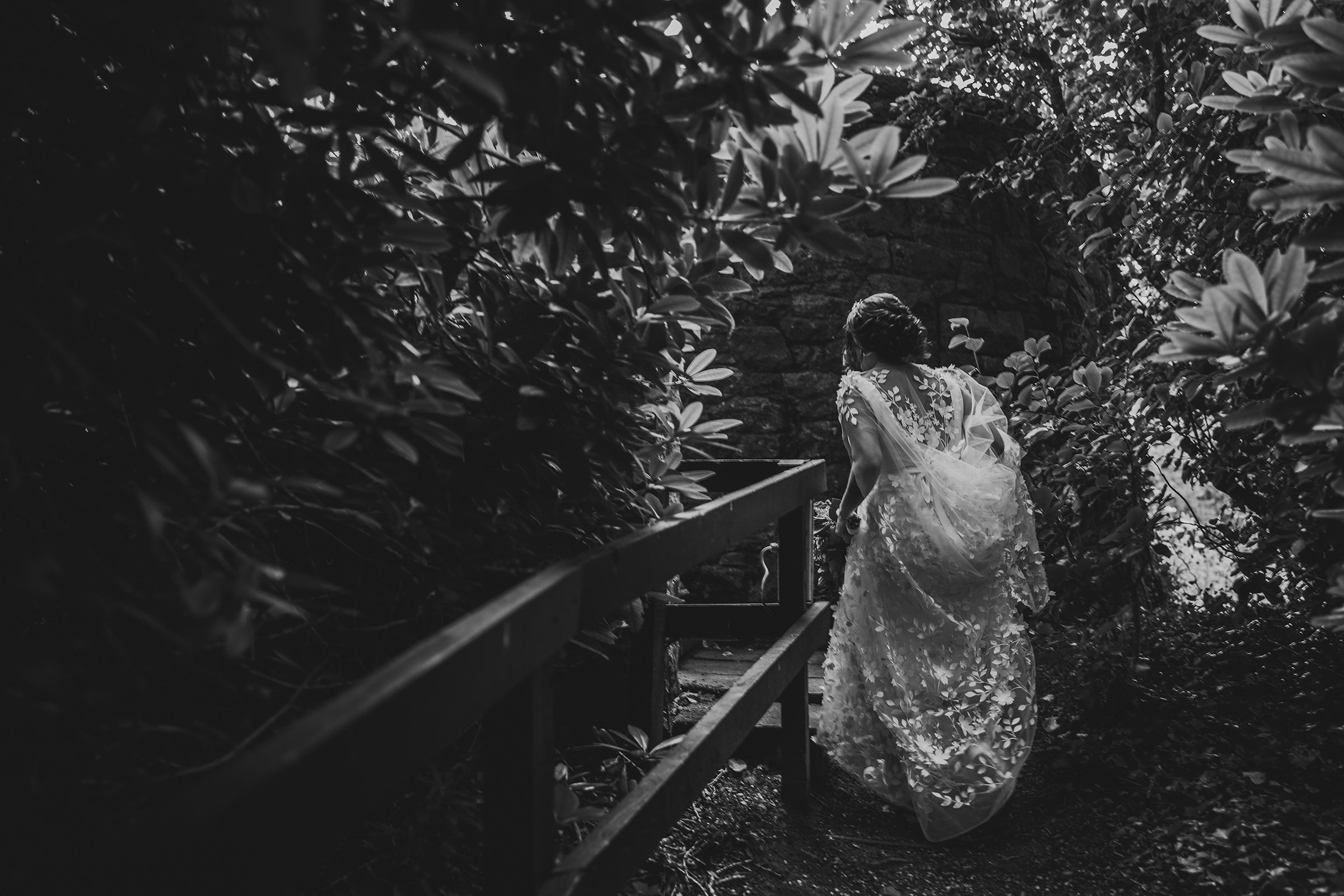 Bride sneaking around garden corner - photo by Katie Kav Photography