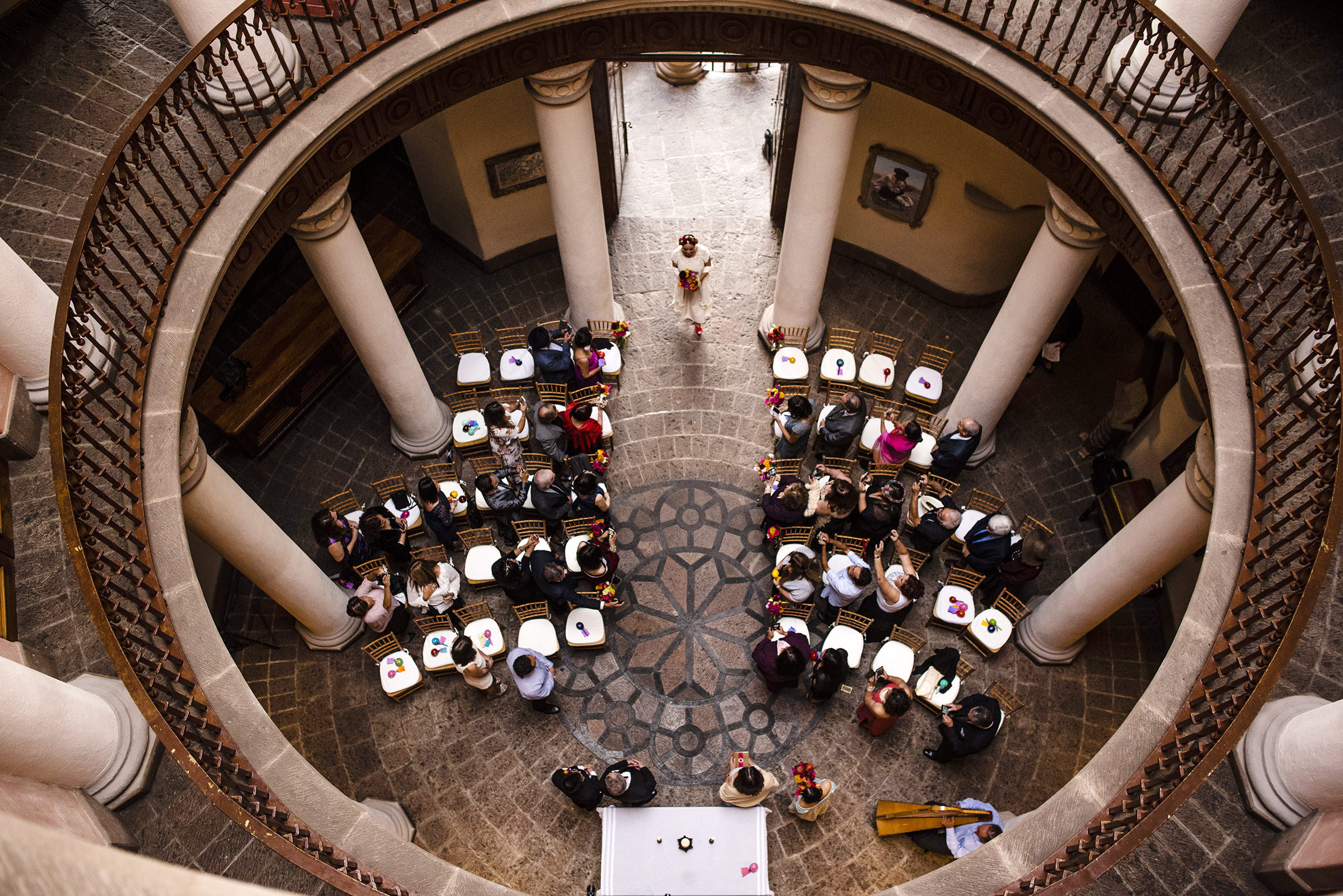 Aerial view of bride entering ceremony in rotunda, photo by Chio Garcia