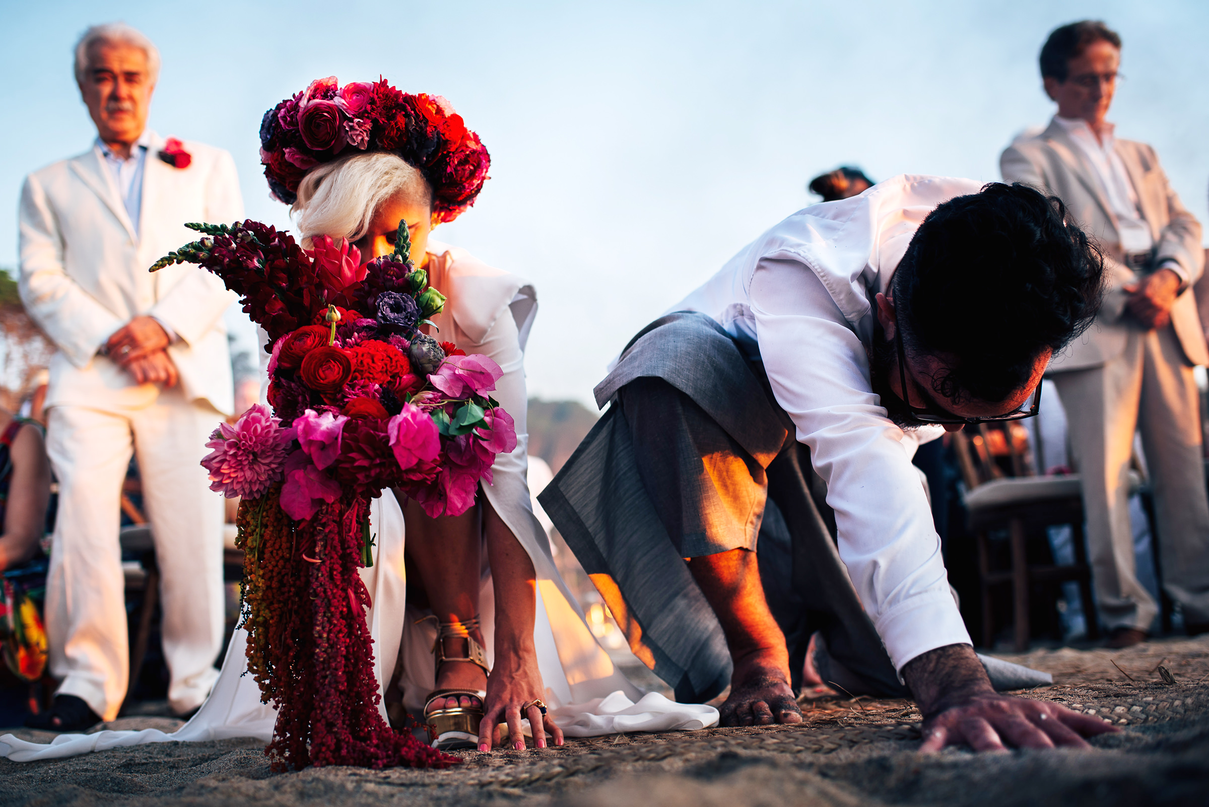 Couple reach to touch ground during ceremony Mexico - photo by Chio Garcia