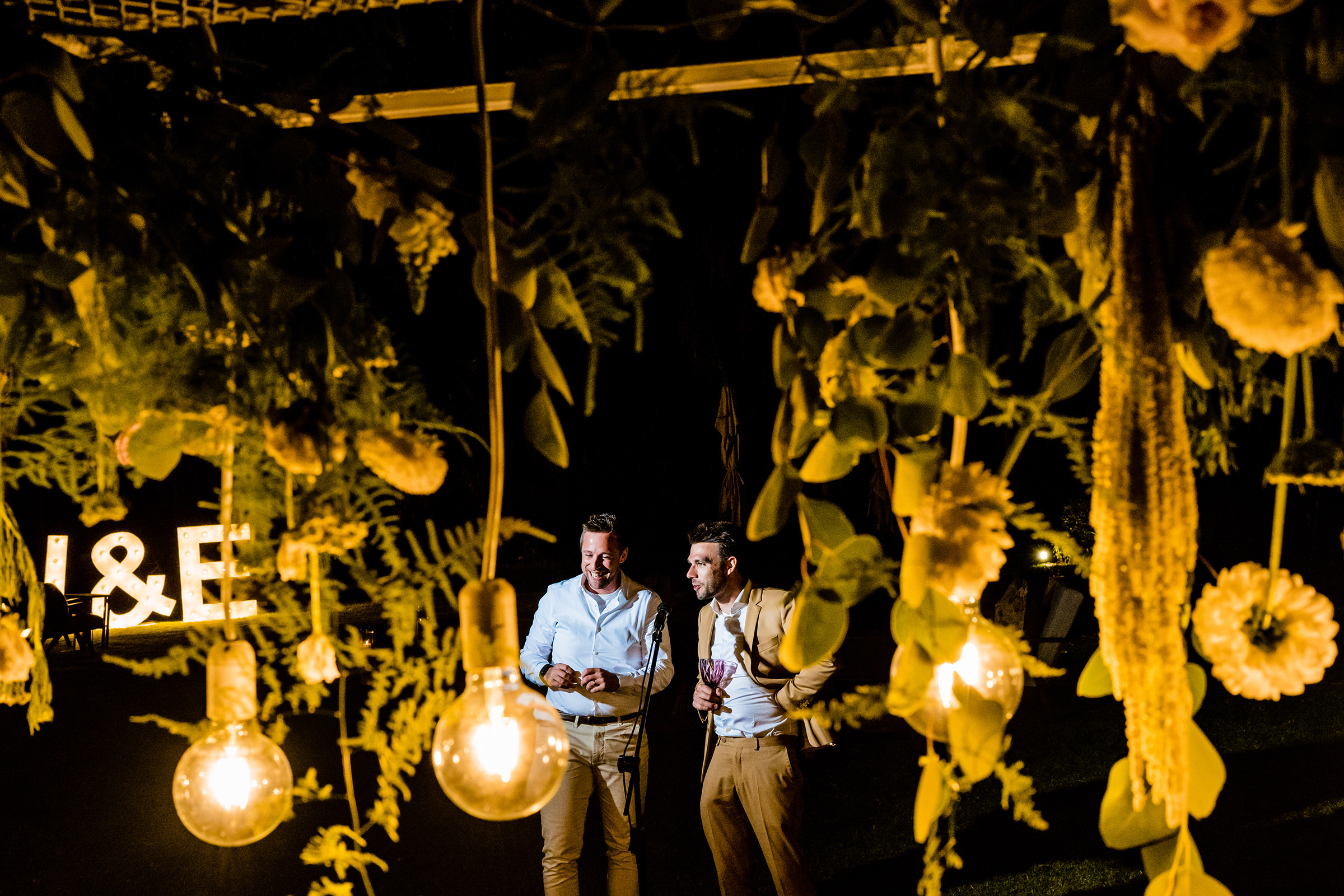Grooms at mike at night time party, photo by Kristof Claeys Photography