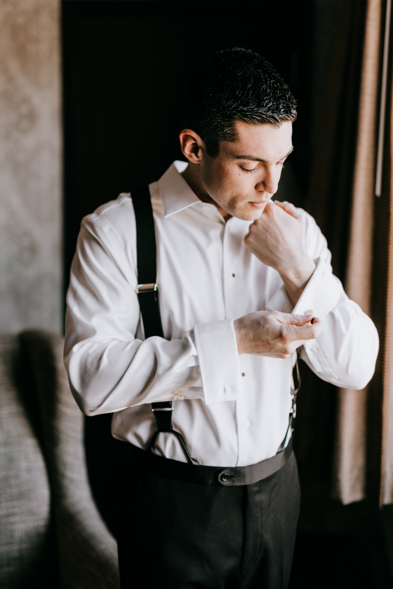 Portrait of groom getting ready in window light, photo by Tom Russo ...