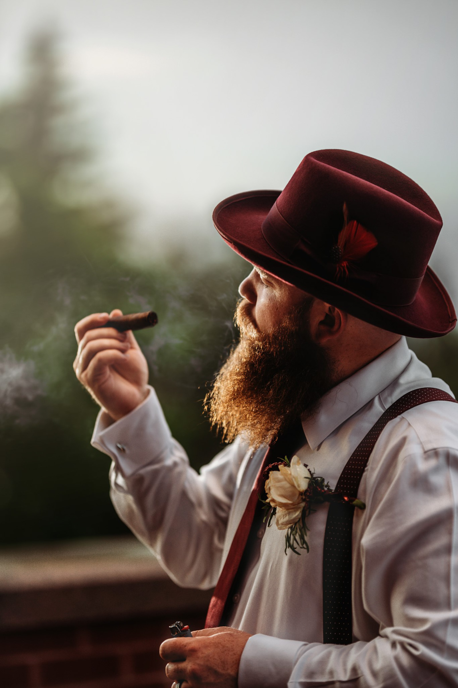 groom wearing a velvet hat smoking a cigar- photo by As the Crow Flies