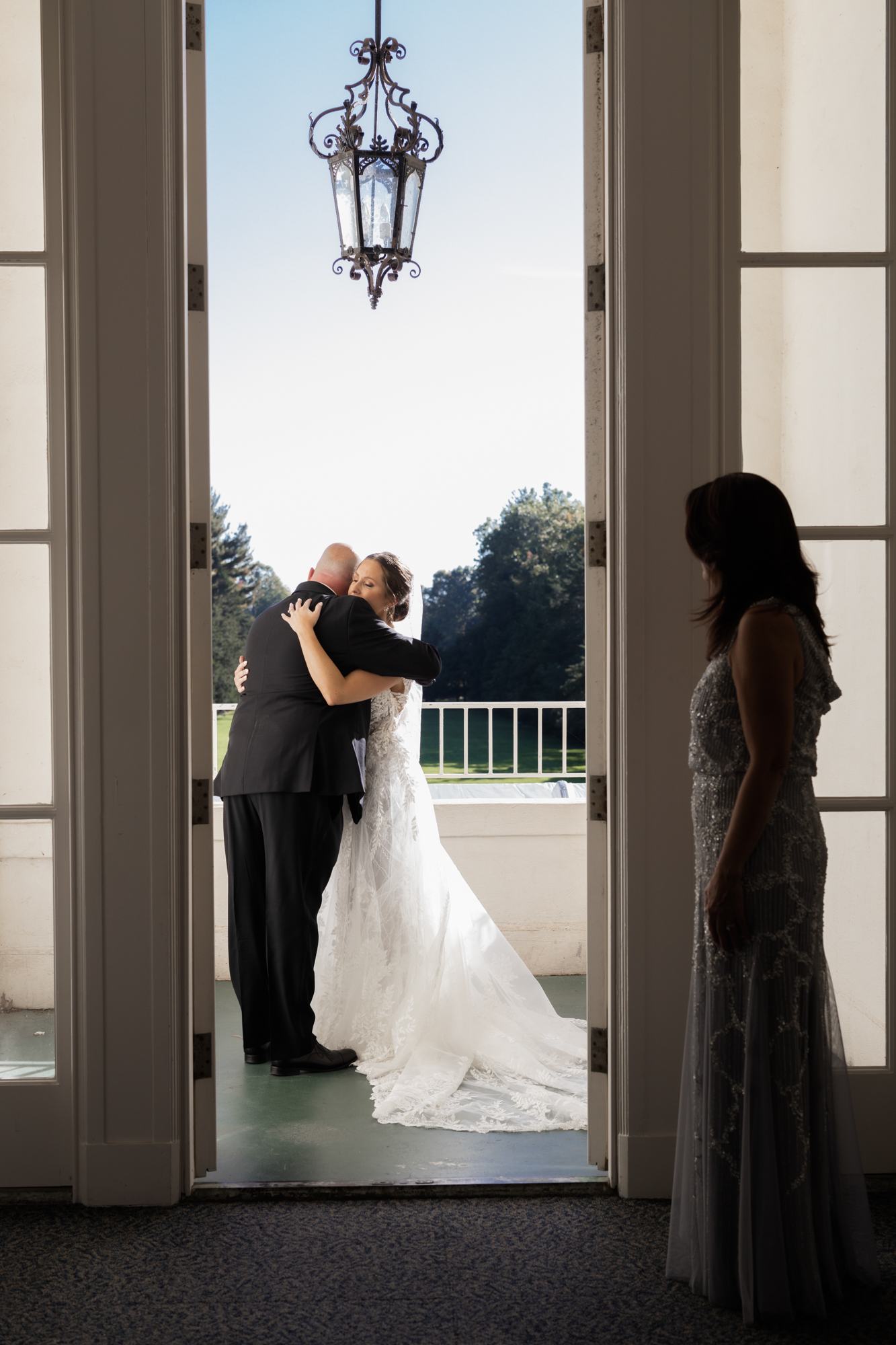 Bride and father embrace as mother looks on, photo by Noah & Jules