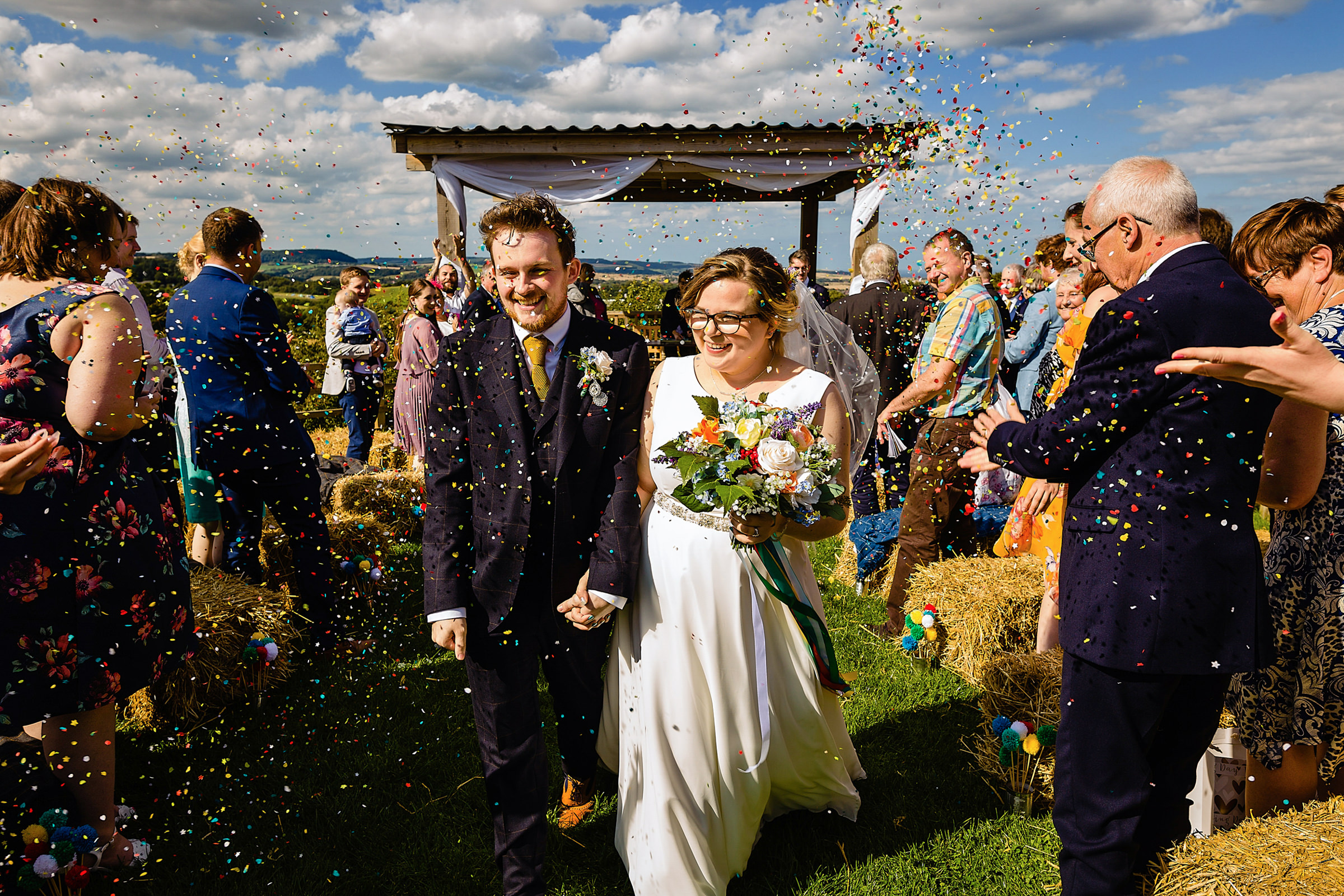 Couple recessional under confetti - photo by Emma + Rich